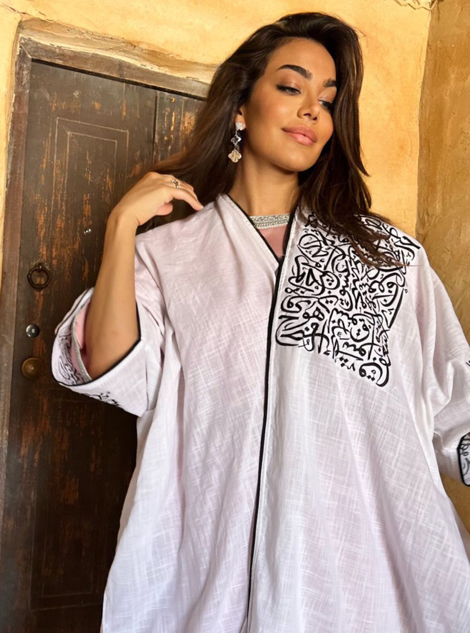 Shaghaf white white oversized abaya with hand-embroidered Arabic calligraphy. Abayas from Maison ...