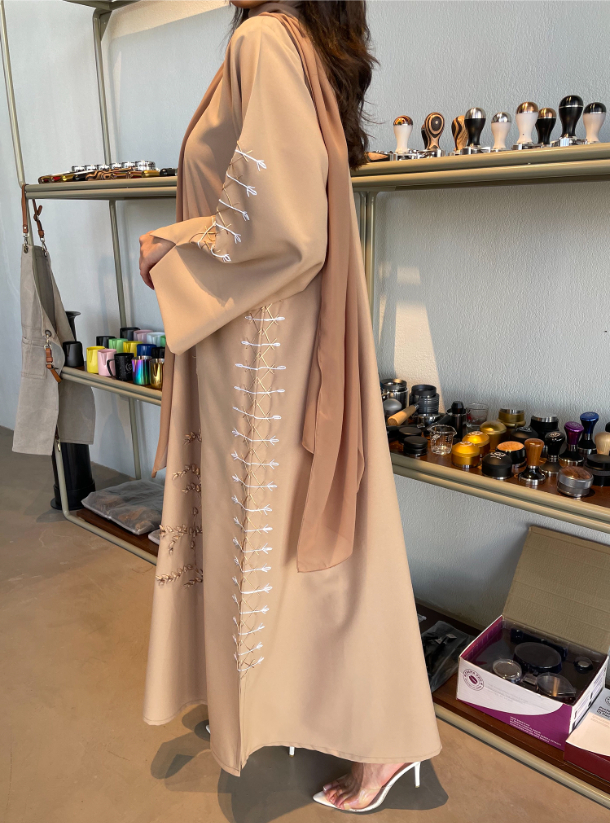 S110 Beige abaya adorned with fabulous strings, comes with matching headscarf. Abayas from Sutra ...