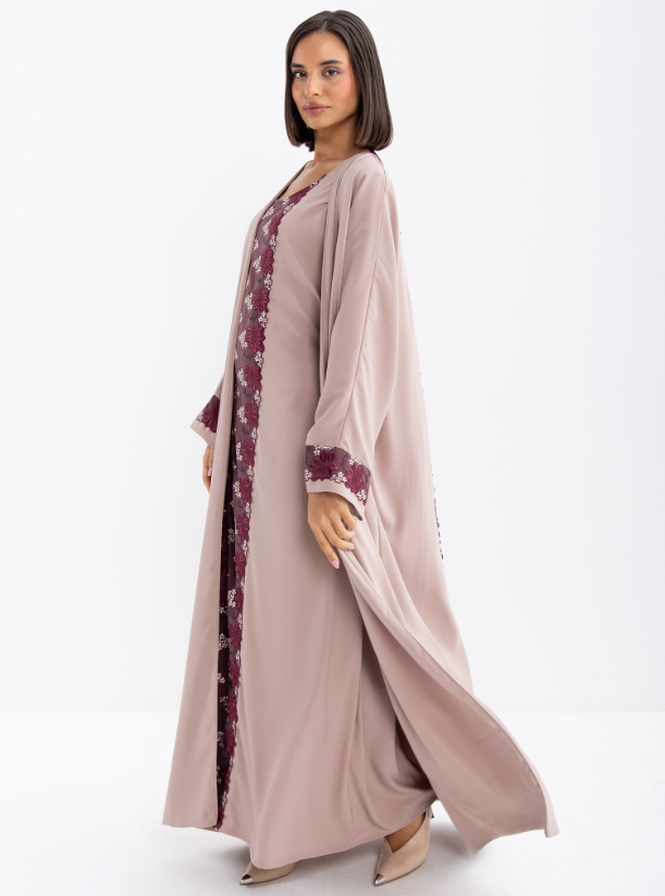 Aura A pink abaya with elegant burgundy embroidery, paired with a ...